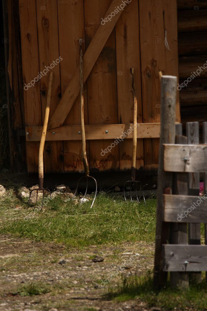 Farming tools by a barn. Stock Photo by ©lightpoet 7422822