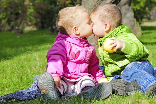 Small children kiss on a green clearing in the autumn — Stock Photo ...