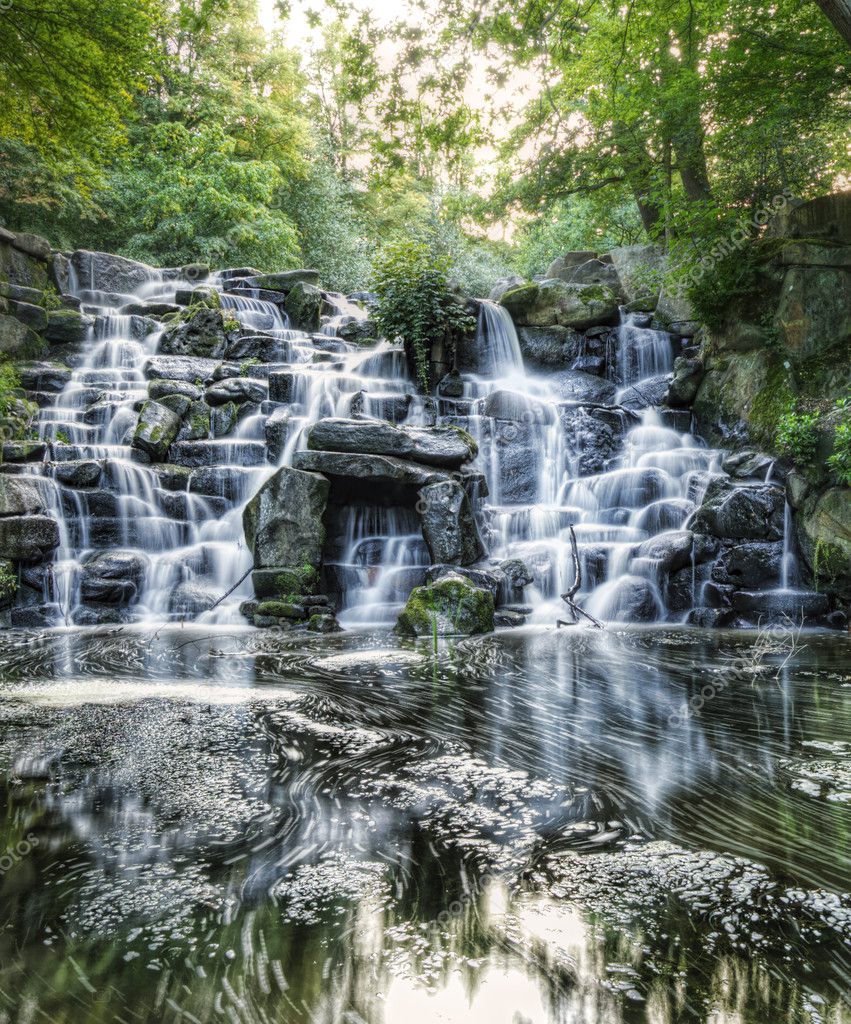 Beautiful waterfall cascades over rocks in lush forest landscape Stock ...
