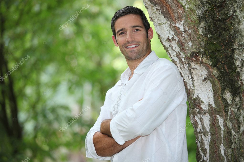Man standing with his arms crossed under a large tree — Stock Photo ...