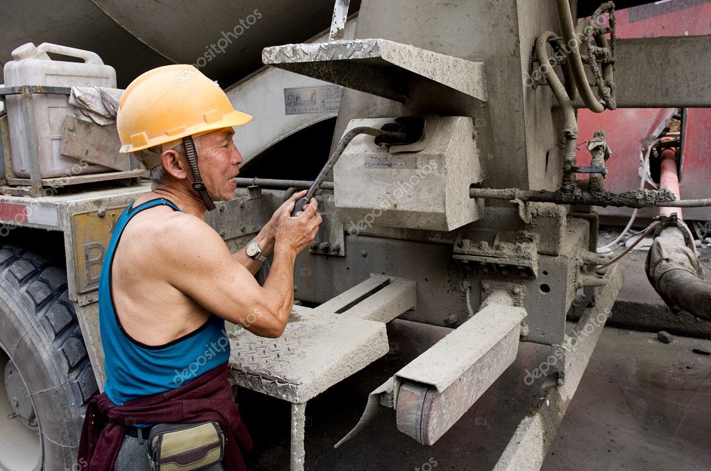 Hardworking laborer and truck-concrete mixer on construction site ...